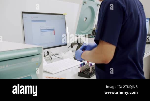 Male doctor places the blood tests in the centrifuge. From above ...