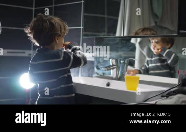 Child brushing teeth at night routine before bed. Kid in front of ...