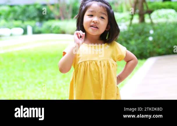 Portrait little girl sing and dance in the park, The girl has a cute ...