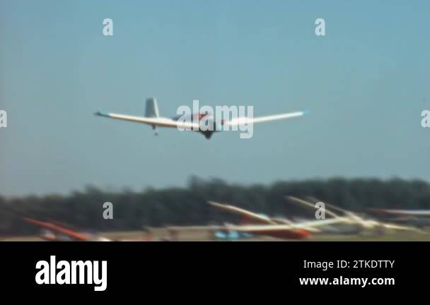 A vintage motor glider lands with a propeller and the engine stopped on ...