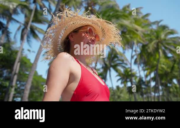 Beautiful Girl In Straw Hat And Red Swimsuit Enjoying Sunbath At Beach