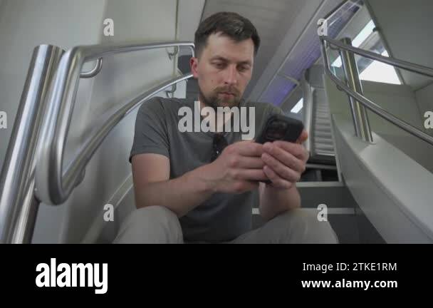 Young man travels on double decker train and sits on flyer using his ...