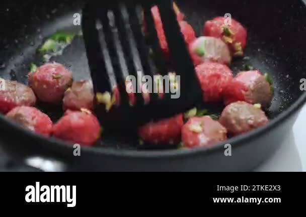 Crop anonymous person turning meatballs frying on electric cooker and ...