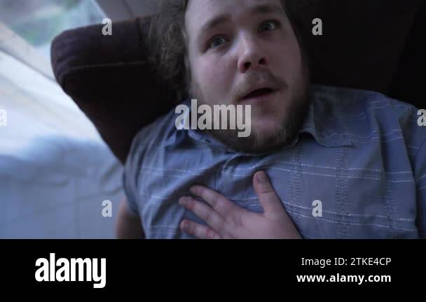 Unwell overweight man suffering from chest pains. A fat guy having ...