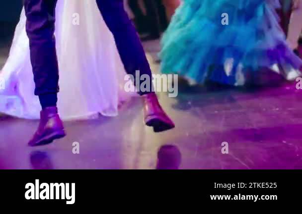 Legs of cheerful man dancing on theater stage with women in elegant ...