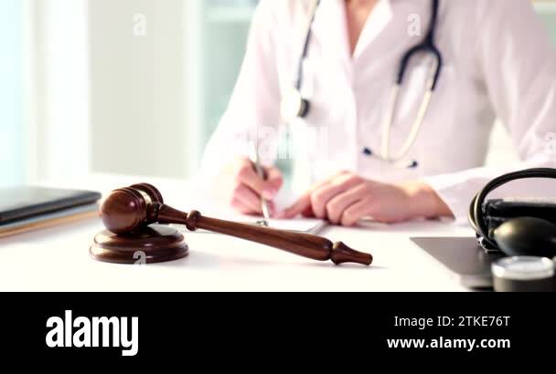 Wooden gavel of judge on table of medical clinic and doctor is filling ...