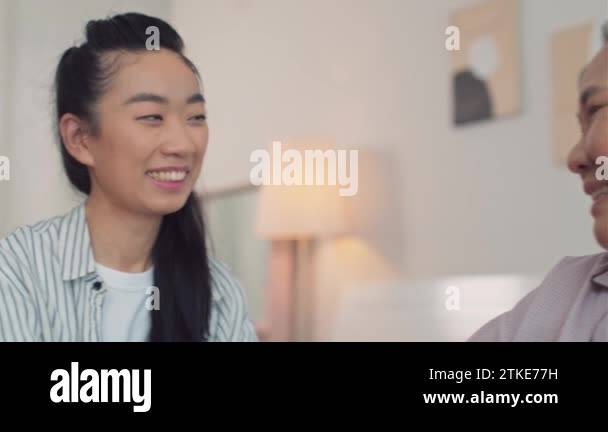 Tilt down shot of daughter holding mothers hand while supporting her ...