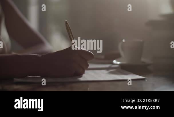 Side view tilt up of concentrated young female musician writing musical ...