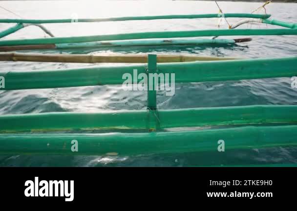 A boat featuring a bamboo outrigger, showcasing the traditional and eco ...