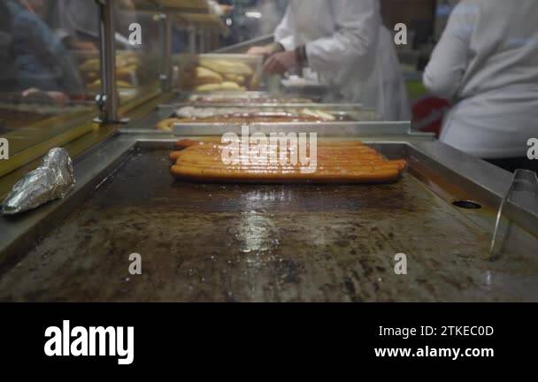 Hands unrecognizable male chefs grill traditional Bavarian sausages at ...