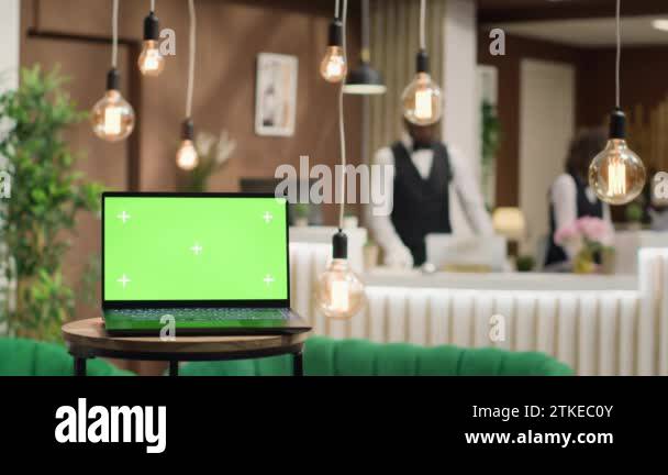 Laptop with blank greenscreen template near hotel reception front desk ...