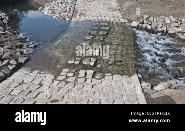 The dirt road leads across a stream that crosses river and continues ...