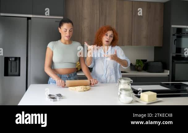 Mother and daughter explaining butter cookies recipe with sign language ...