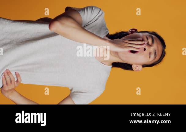 Vertical video: Drained person yawning and being tired in studio ...