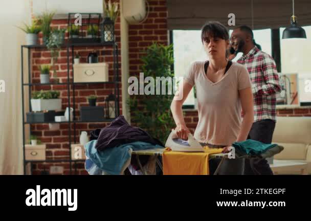 Modern person ironing washed clothes feeling depressed about doing ...