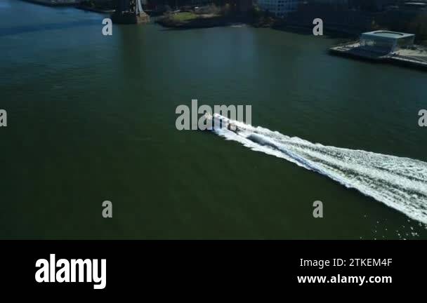 High angle view of motorboat driving on water surface and making waves ...