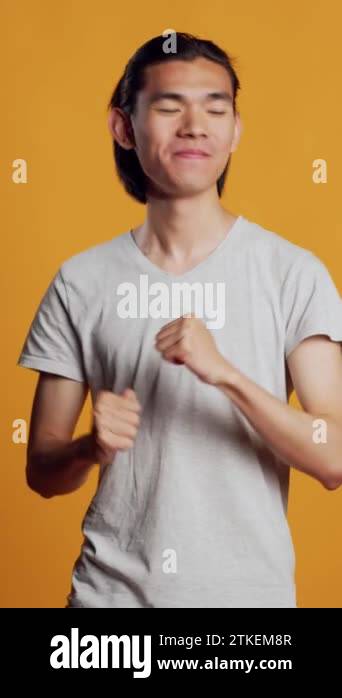 Vertical video: Asian man showing cool dance moves on camera, having ...