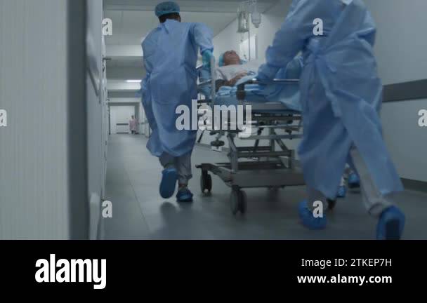 Doctors, nurses and paramedics run and push stretcher with seriously ...
