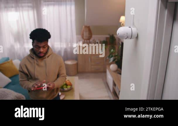 African American man completes installation of security camera. Man ...
