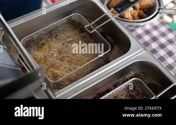 Huge amounts of oil boiling inside of the deep fryer. Cooking the food ...