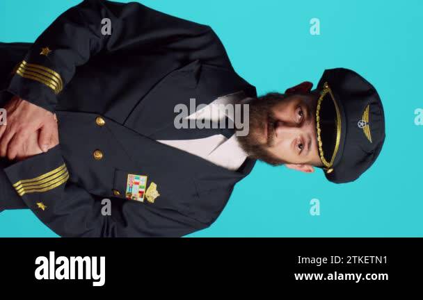 Vertical video: Male plane captain wearing airline uniform and posing ...