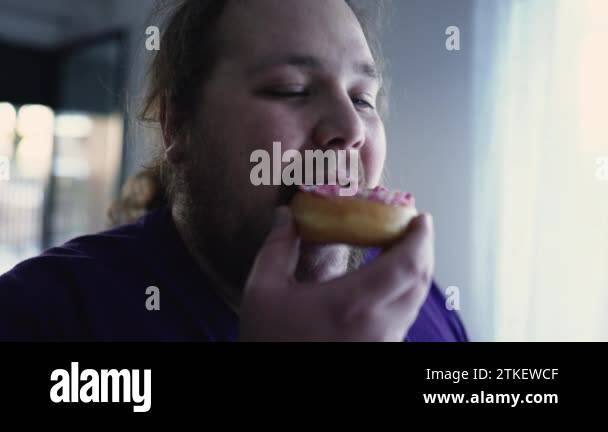 One fat man eating donut. Overweight person taking a bite of junk food ...
