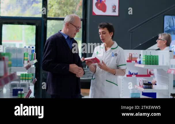 Experienced pharmacist in drugstore offering elderly customer ...