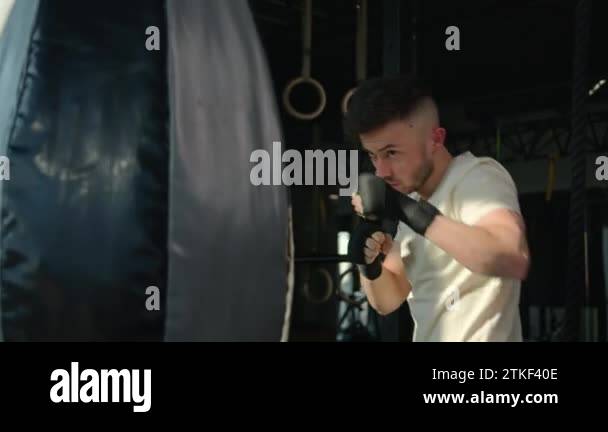 Male sportsman Caucasian man boxer training with punching bag boxing ...