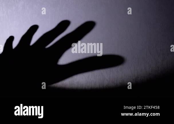 Shadow of Long Black Fingers of a Monster on Wall by the Light of a ...
