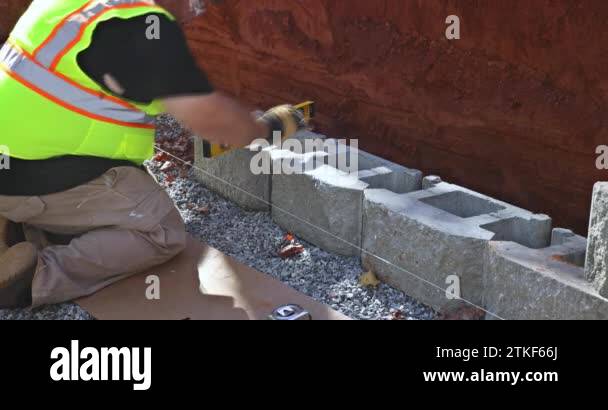 Construction worker was mounting concrete blocks to retaining wall on ...