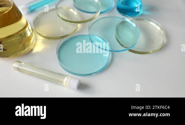 Various glassware and test tubes with light blue liquid and oil in ...