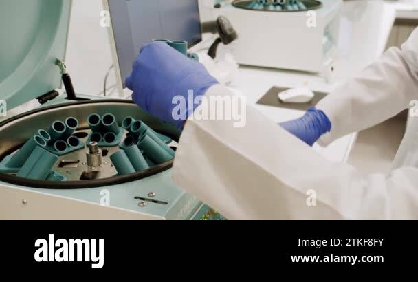 Male doctor places the blood tests in the centrifuge. From above ...