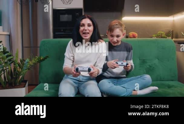 Mother and son playing video game using controllers when they spend ...