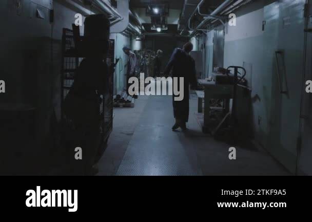 Rear of female apocalypse survivor with shaved head holding shotgun ...