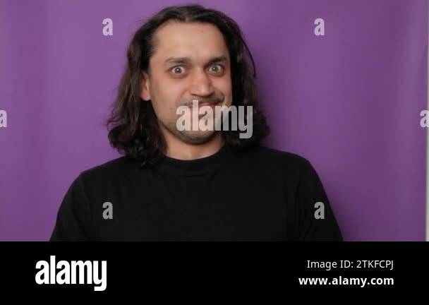 A funny, handsome guy shows indecent hand gestures. Portrait of a young ...