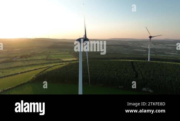 Aerial. Wind turbines standing at sunset. Aerial photo of a farm with ...