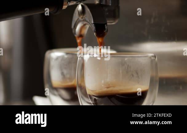 Pouring a coffee jet from a professional machine into a cup. A man ...