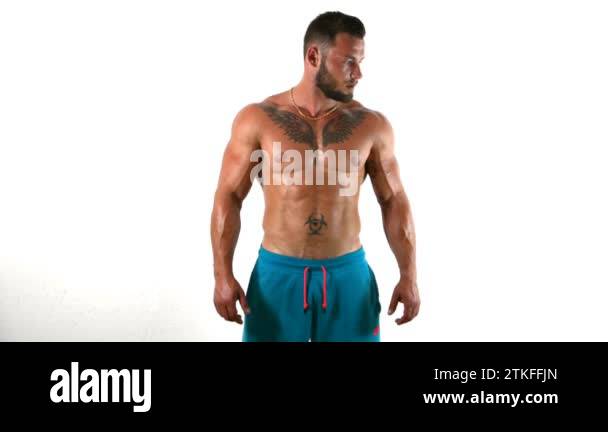 Shirtless muscular man standing in relaxed pose, looking at camera ...