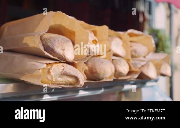 Baked loaves of bread in paper packages on the store shelf, hot crusty ...