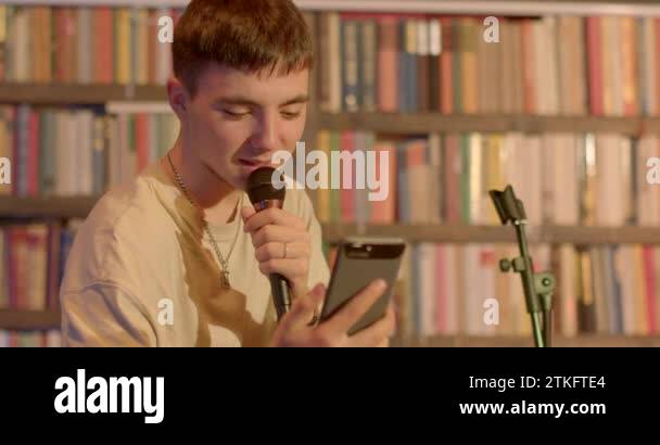 A stand-up comedian performs on stage using a phone in a monologue. He ...