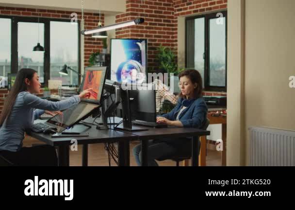 Smiling coworker talking to 3D developer about digital art production, explaining graphics ...