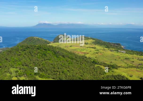 Tropical landscape with hills covered with green vegetation and blue ...