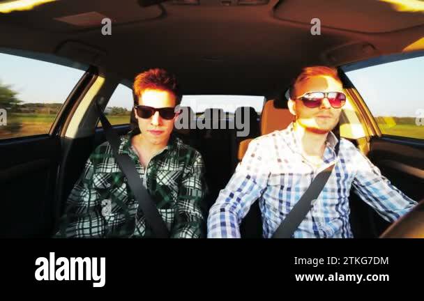 Two men driving in car having fun speaking Stock Video Footage - Alamy