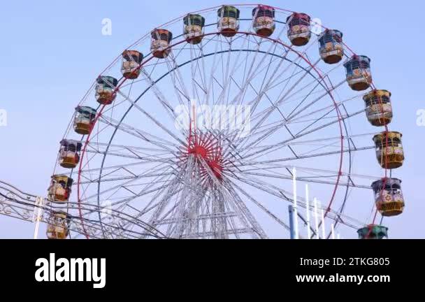 A close view of the giant wheel or ferris wheel and crowd of people at ...