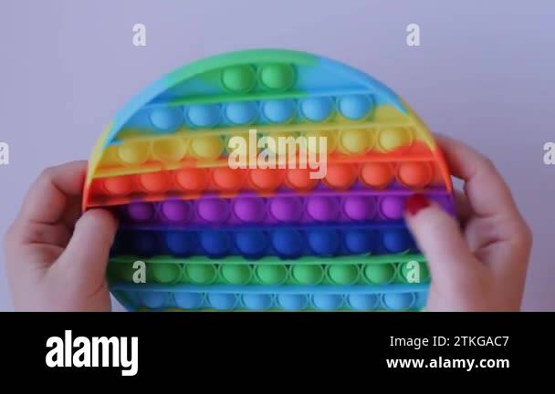 Women hands crumple and play with large round Pop It close-up top view ...