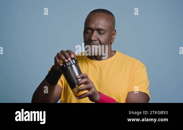 Mature african american man athlete in blue background studio shaking ...