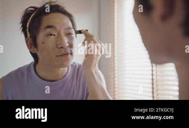 Gay queer man non-binary beauty blogger makeup artist at home cross ...