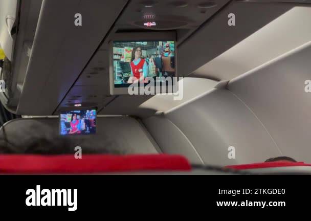 Two multimedia monitors in the middle of a commercial airplane playing ...