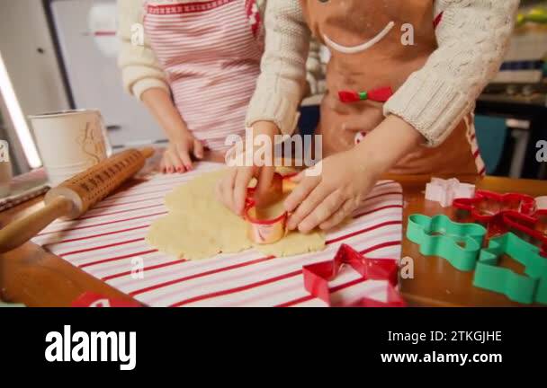 Close up top view of childs hand making cookie in gingerbread man shape ...