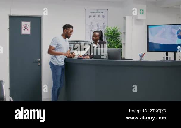 Male patient using mobile phone to pay with nfc on pos terminal, making ...